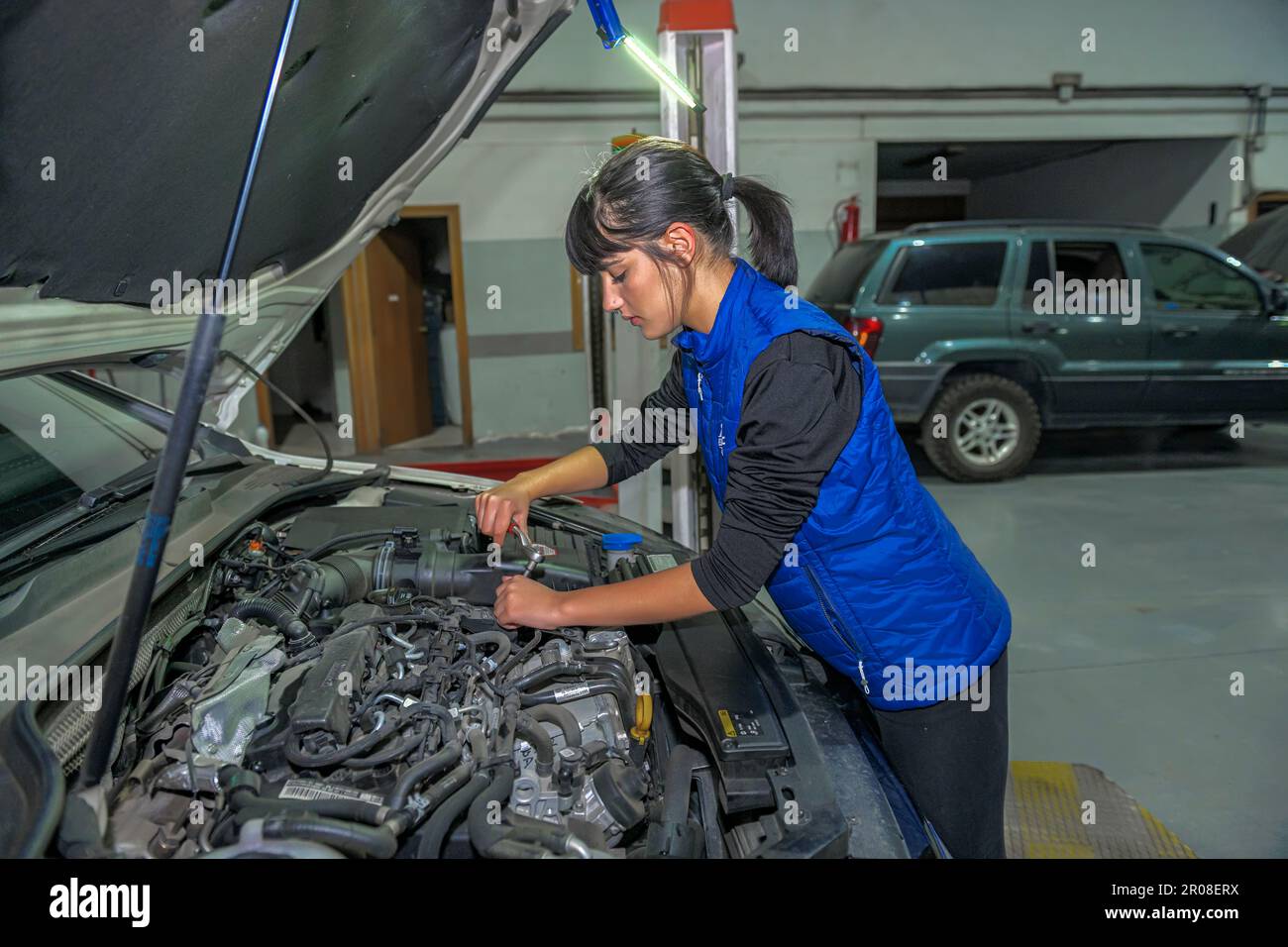 Young female mechanic, working on the repair of a car engine Stock ...