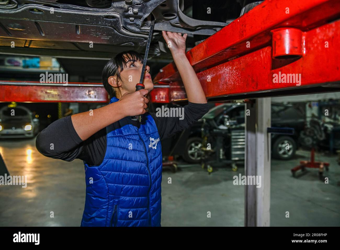 Young female mechanic, working on the repair of a car engine Stock ...