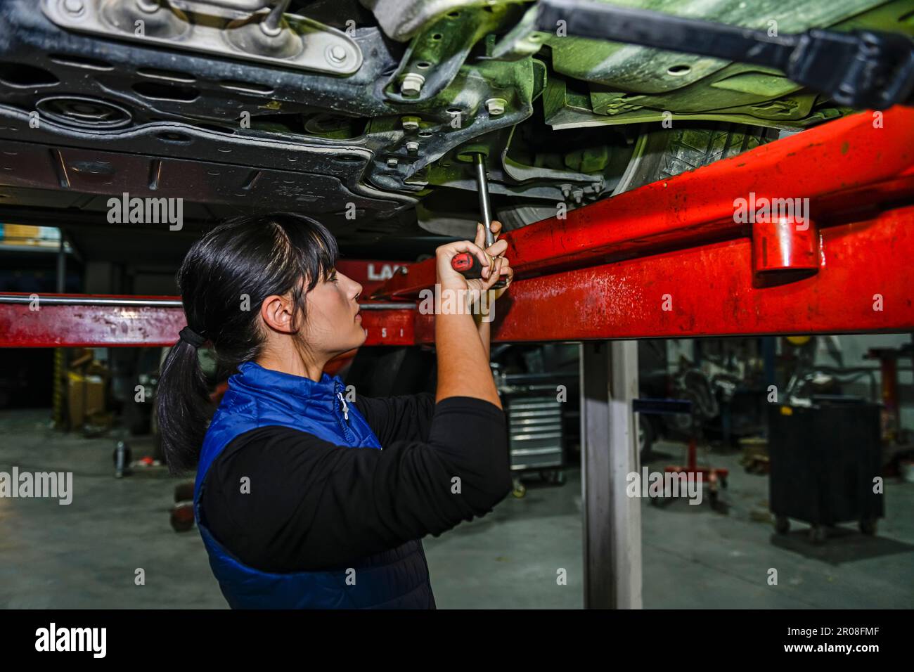 Young female mechanic, working on the repair of a car engine Stock ...