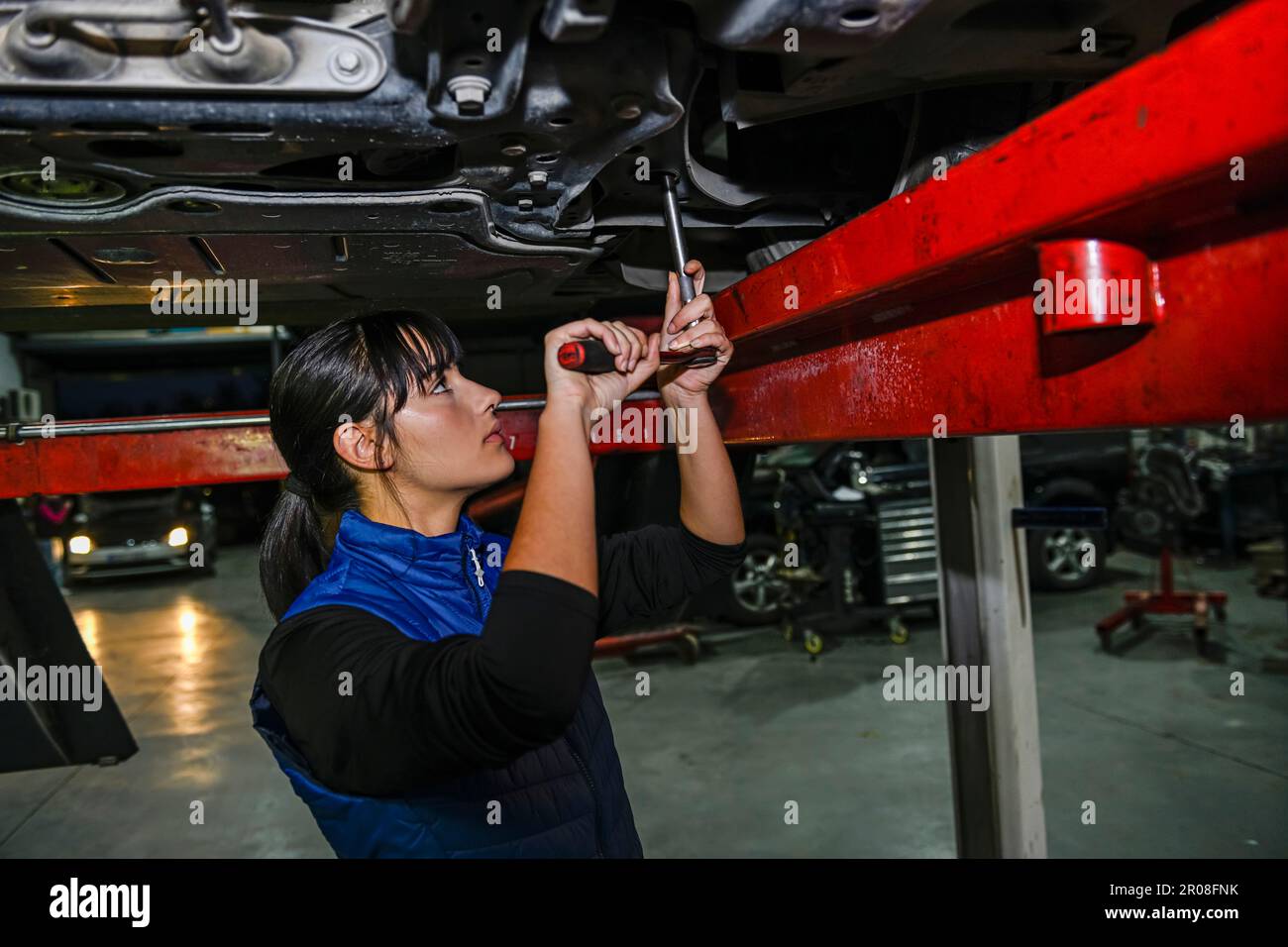 Young female mechanic, working on the repair of a car engine Stock ...