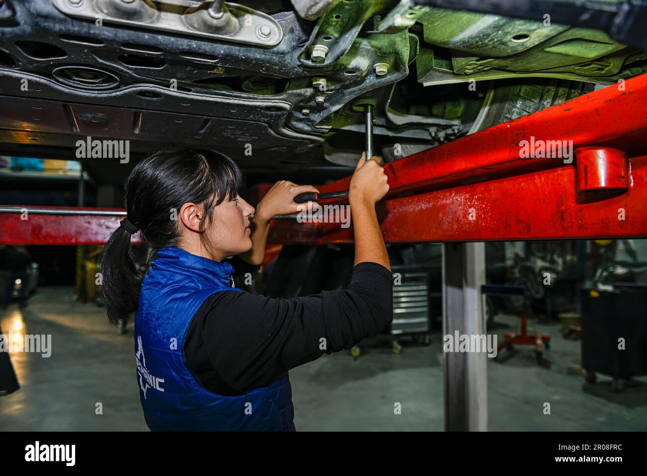 Young female mechanic, working on the repair of a car engine Stock ...