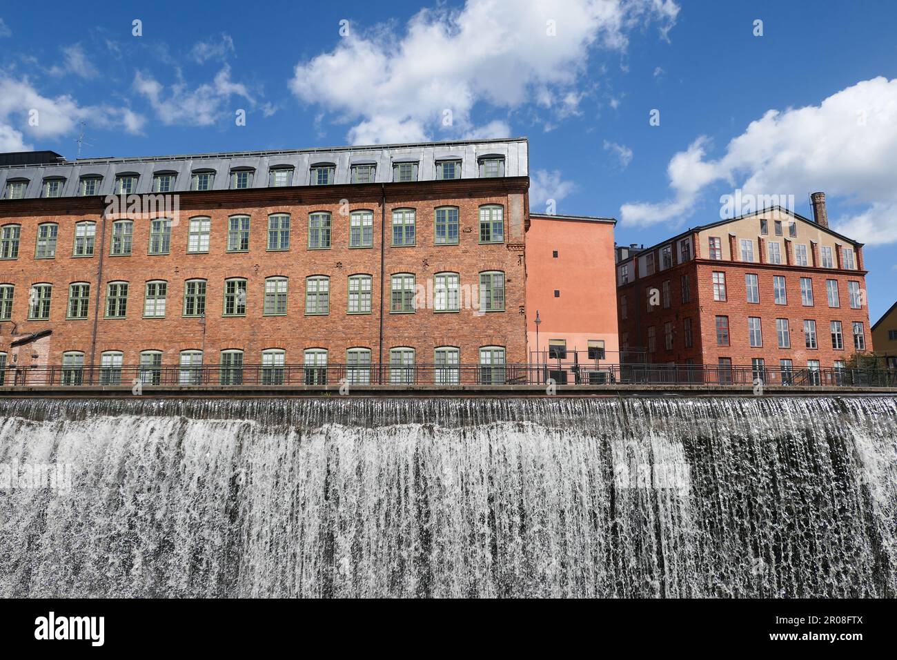 Low angle view of buildings next to a waterfall Stock Photo - Alamy