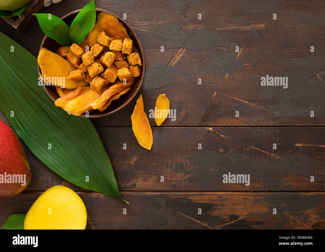 Mango dried slices and balls in bowl plate on wooden background.Top ...