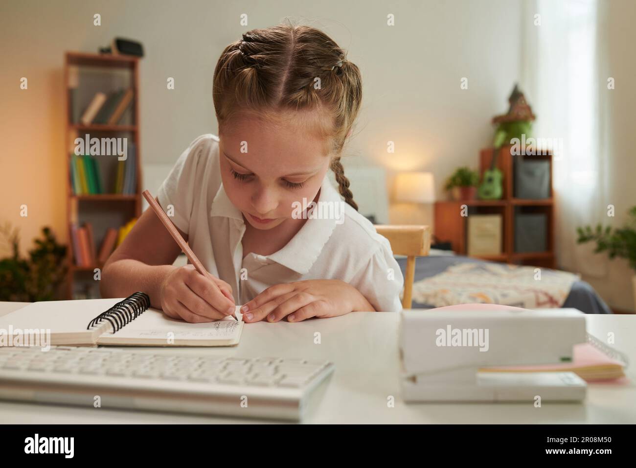 Schoolgirl doing homework for math class at desk in her bedroom Stock ...