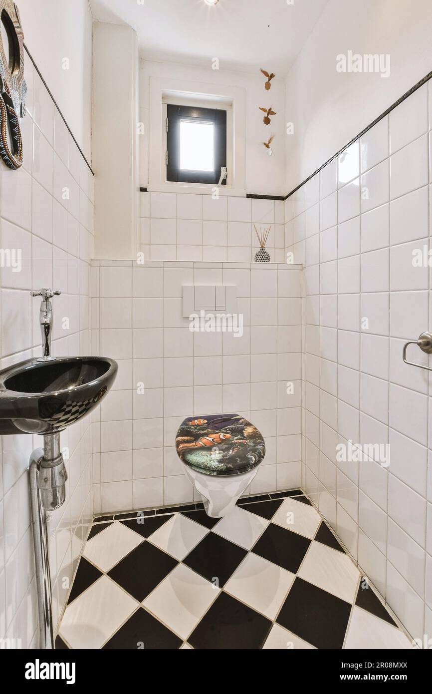 a black and white checkered floor in a bathroom with a toilet, sink and ...
