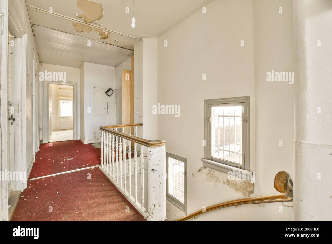 the inside of an old house with red carpet and peeling paint on the ...