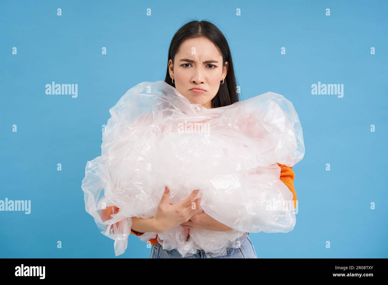 Asian sad woman holding plastic garbage and frowning from ...