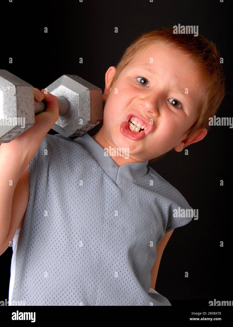 Young boy lifting weight that is too heavy Stock Photo - Alamy