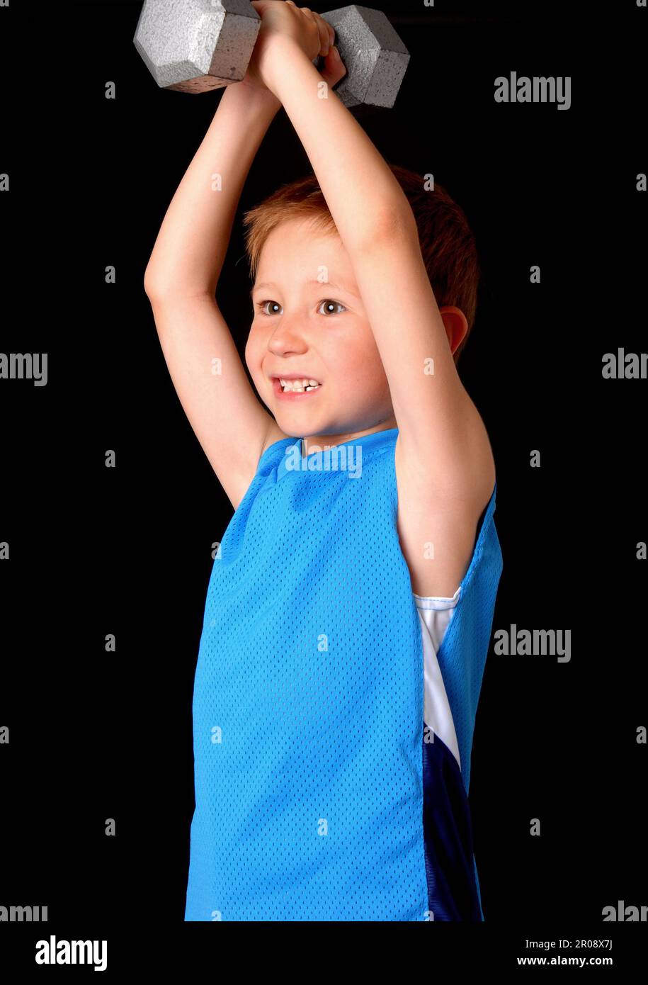 Young boy lifting weight that is too heavy Stock Photo - Alamy