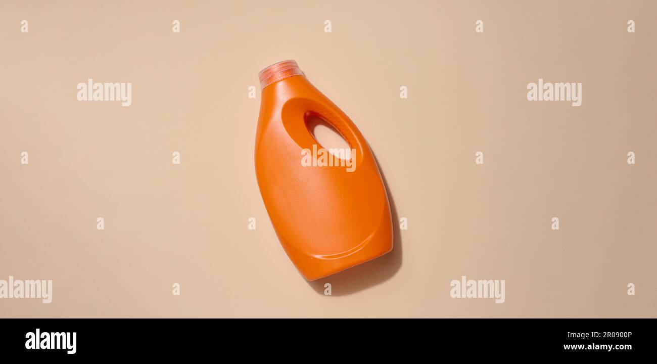 Orange plastic bottle for liquid detergents, for washing clothes on a ...