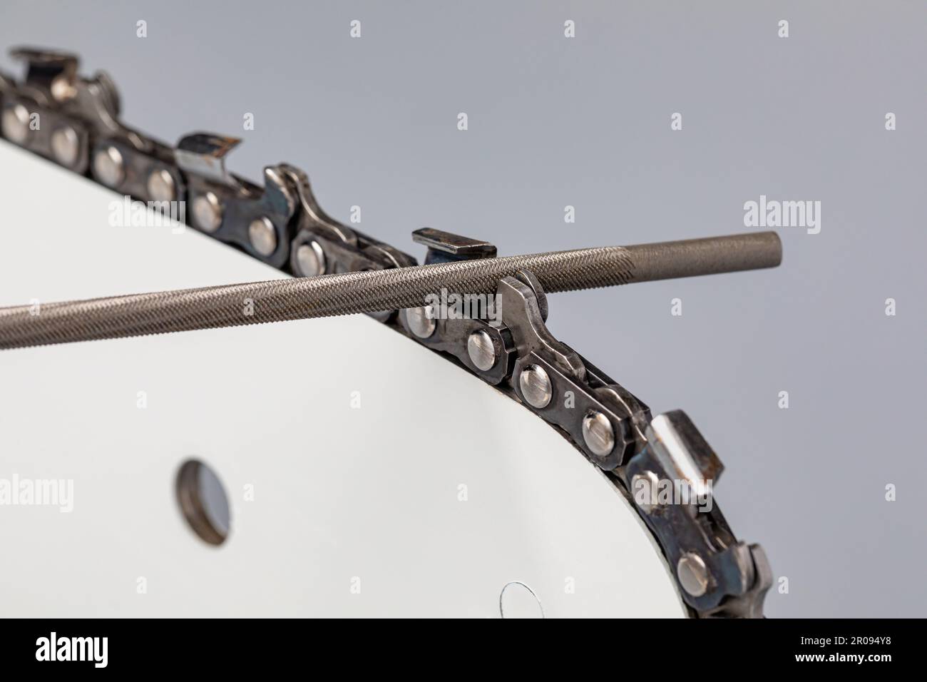 Sharpening chainsaw chain with file. Chain saw and lawn equipment ...