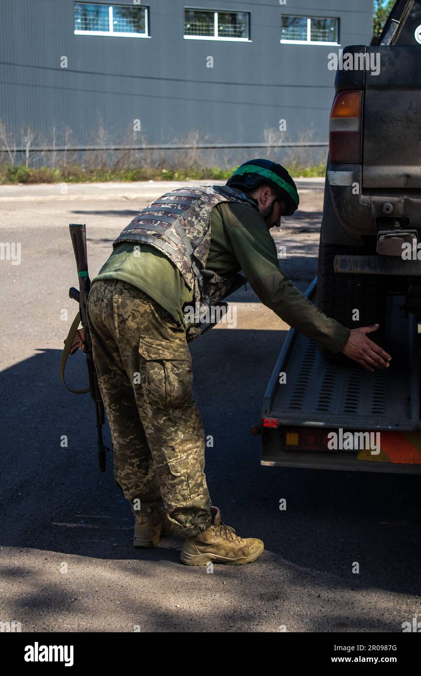 Ukrainian soldier loading a combat vehicle damaged by shrapnel from the ...