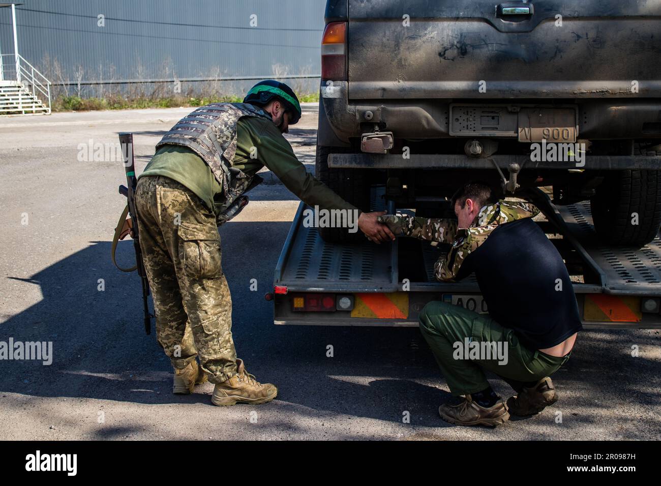 Ukrainian soldier loading a combat vehicle damaged by shrapnel from the ...