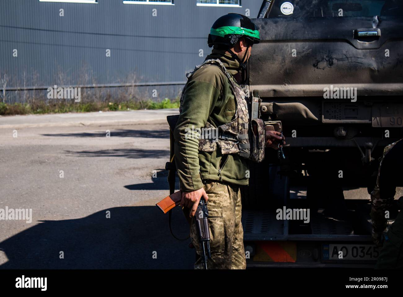 Ukrainian soldier loading a combat vehicle damaged by shrapnel from the ...