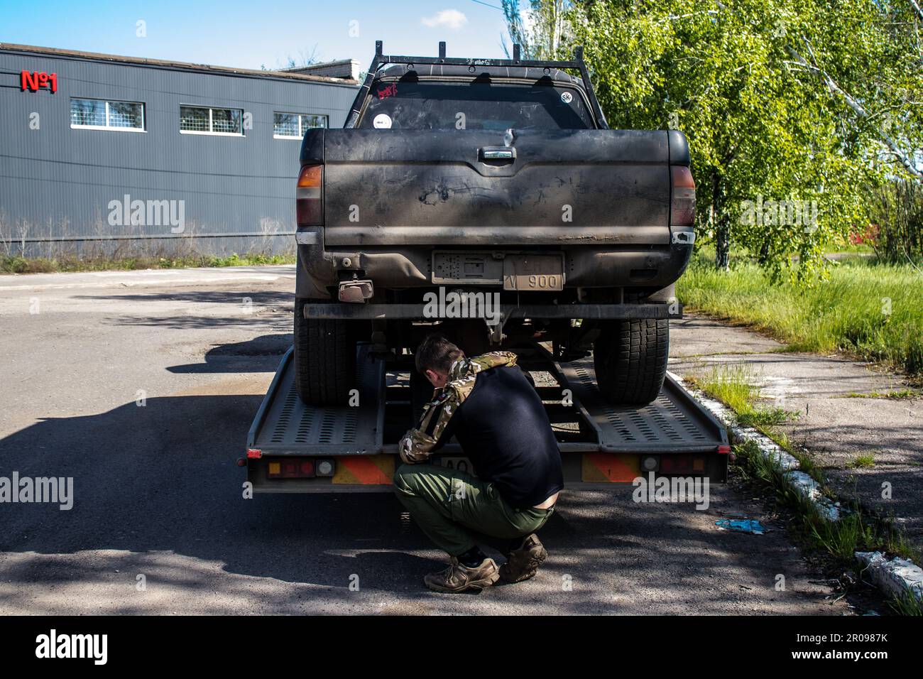 Ukrainian soldier loading a combat vehicle damaged by shrapnel from the ...