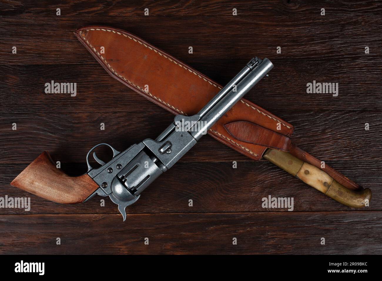 Old west weapon. Colt Revolver and knife with holster on wooden deck ...