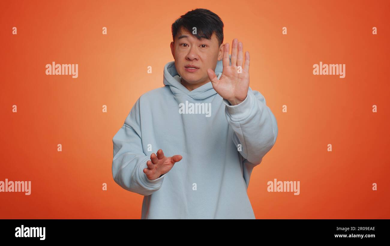 Asian man say No hold palm folded crossed hands in stop gesture ...