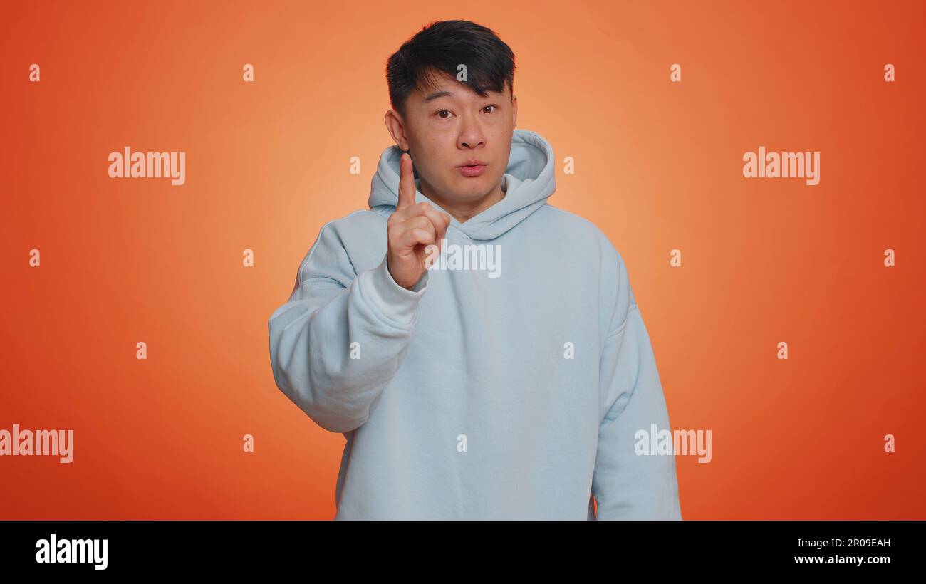 Asian handsome man shakes finger and saying No, be careful, scolding ...