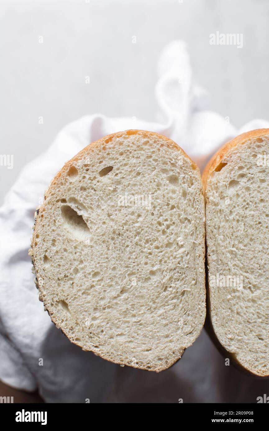 Cross-section of artisan bread cut into half, top view of sesame coated ...