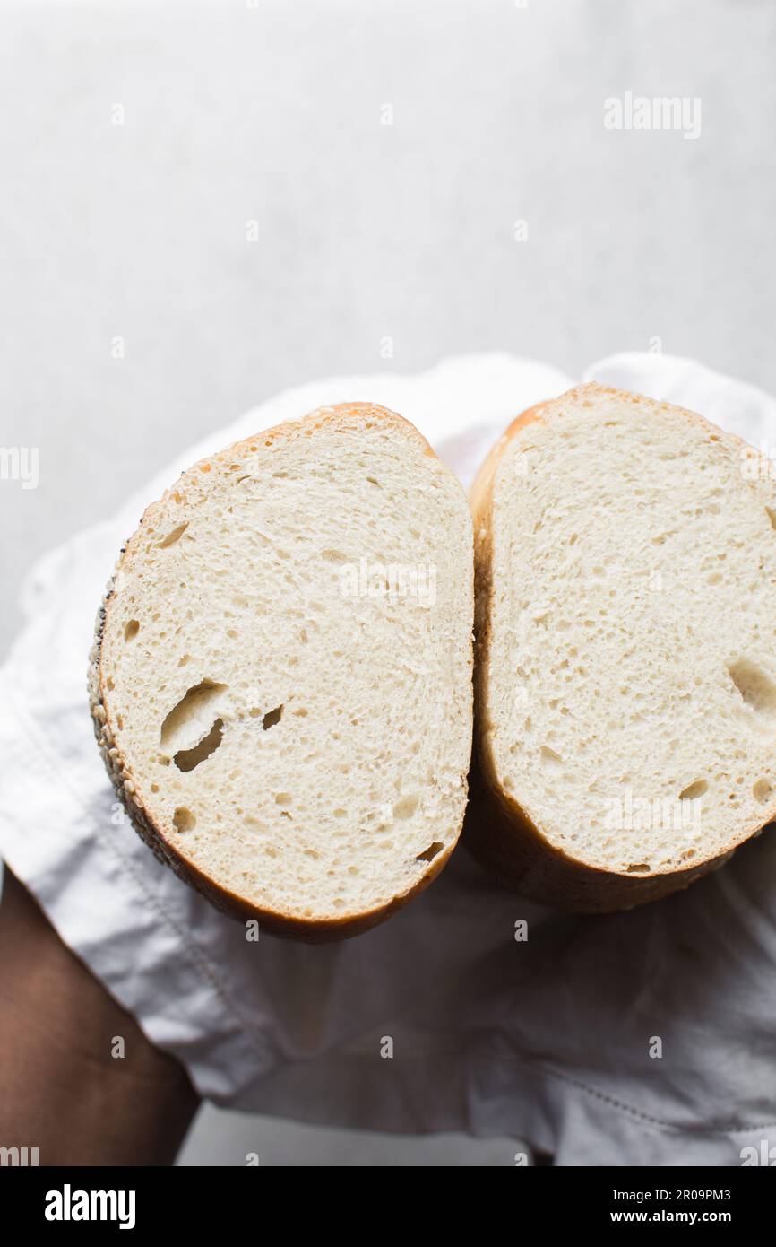 Cross-section of artisan bread cut into half, top view of sesame coated ...