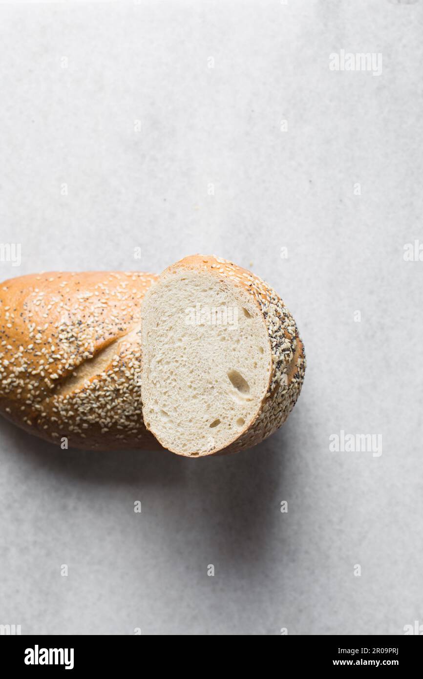 Loaf of artisan bread topped with sesame seeds cut into half, top view ...