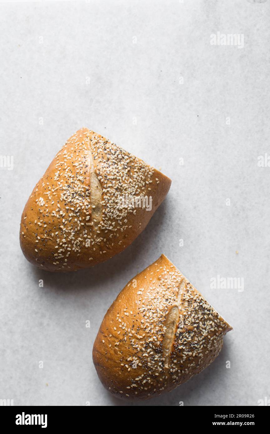 Loaf of artisan bread topped with sesame seeds cut into half, top view ...