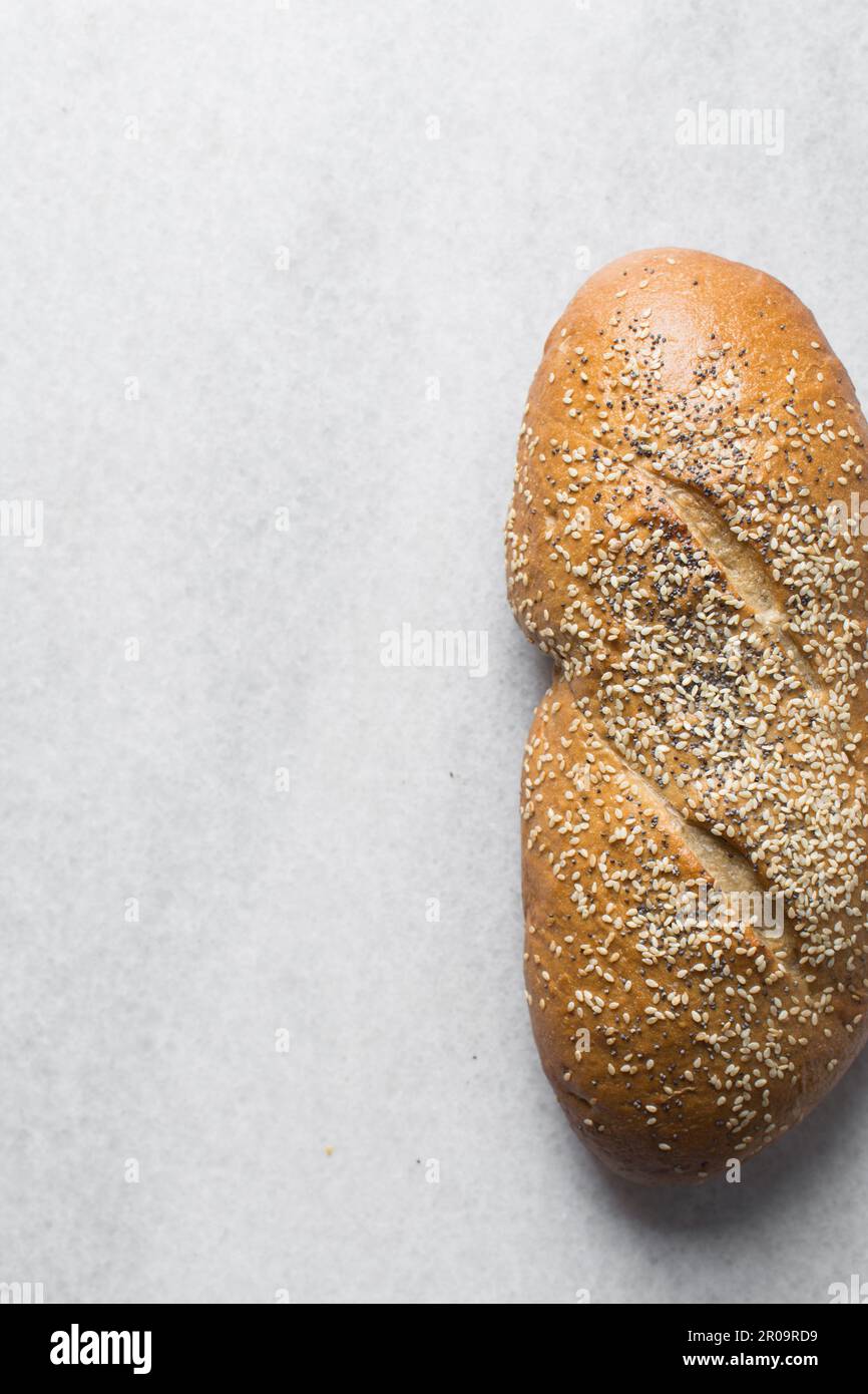 Loaf of artisan bread topped with sesame seeds on a marble countertop ...