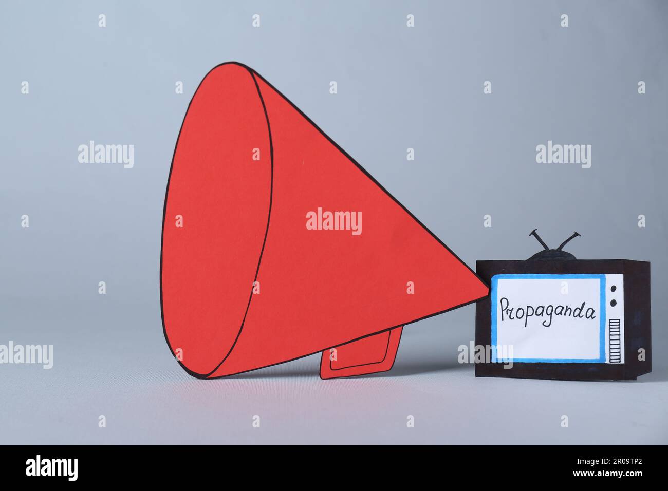 Propaganda concept. Big paper megaphone and TV on light grey background ...