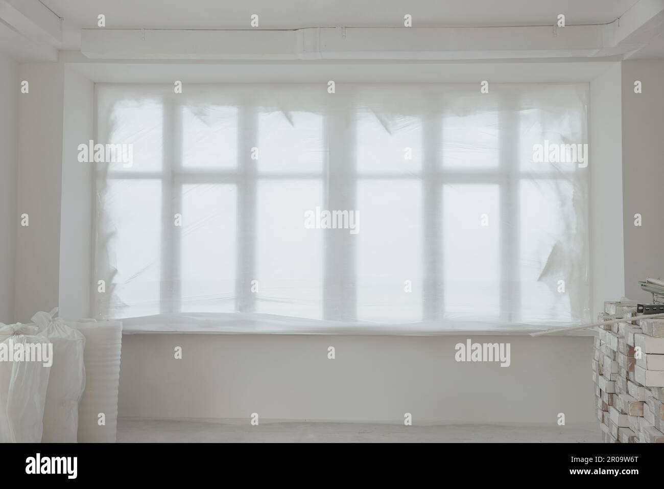 Windows covered by plastic film and building materials in renovated ...