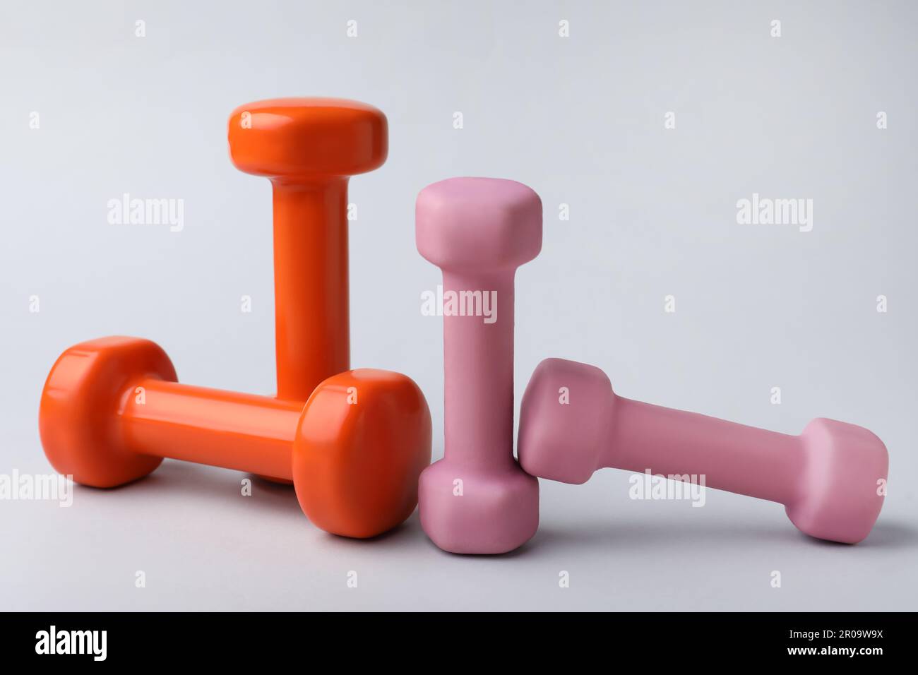 Set of colorful dumbbells on light background Stock Photo - Alamy