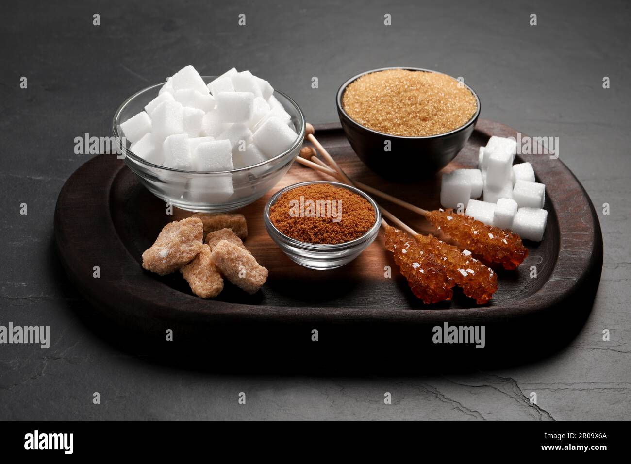 Different types of sugar on black table, closeup Stock Photo - Alamy