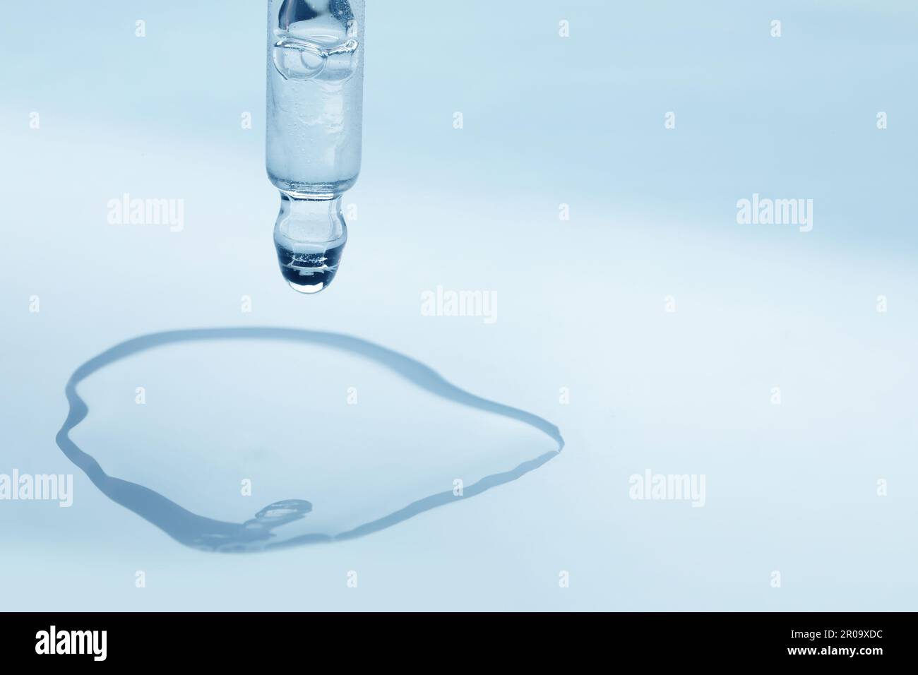 Dripping face serum from pipette on white background, closeup. Space ...