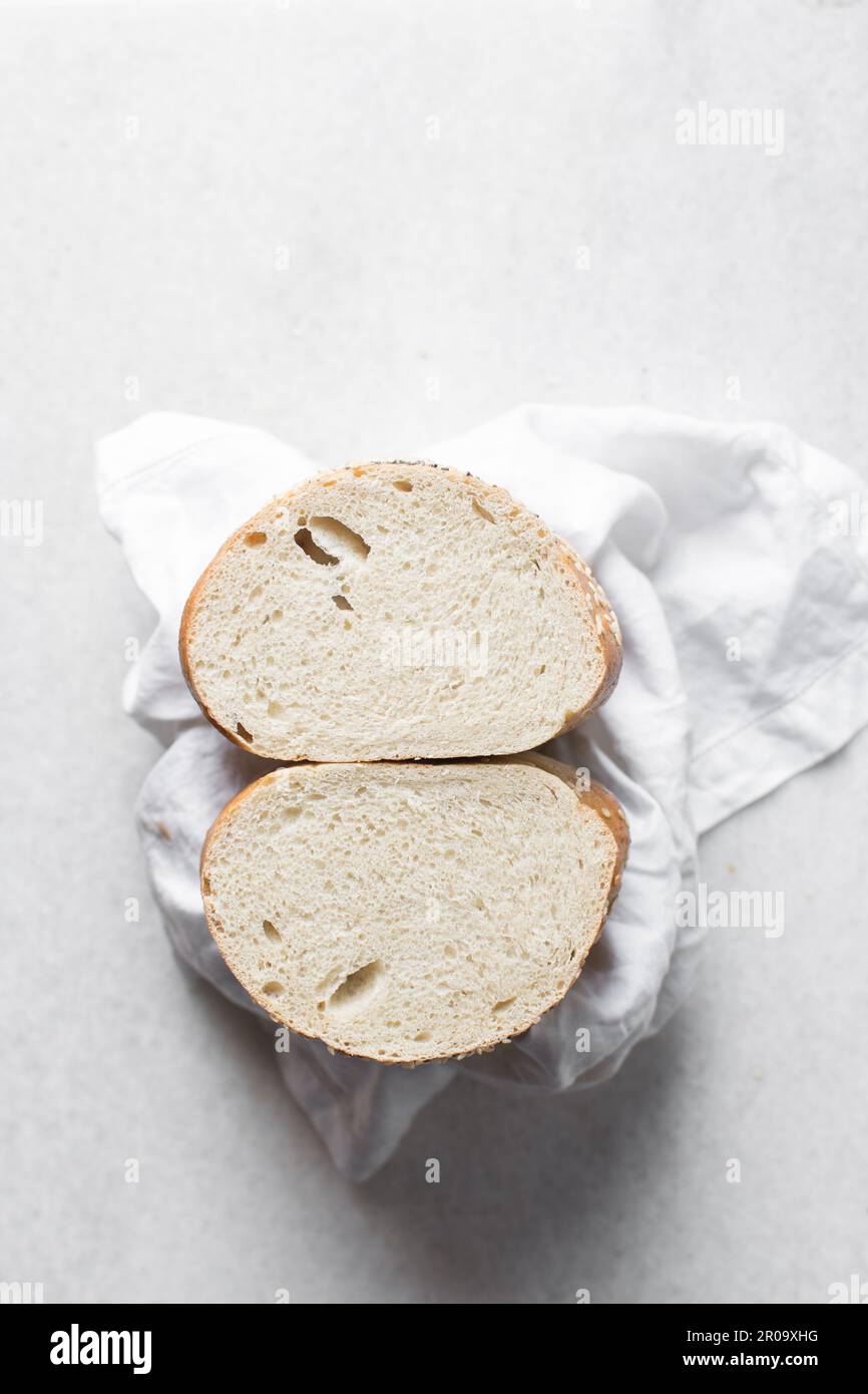 Cross-section of artisan bread cut into half, top view of sesame coated ...