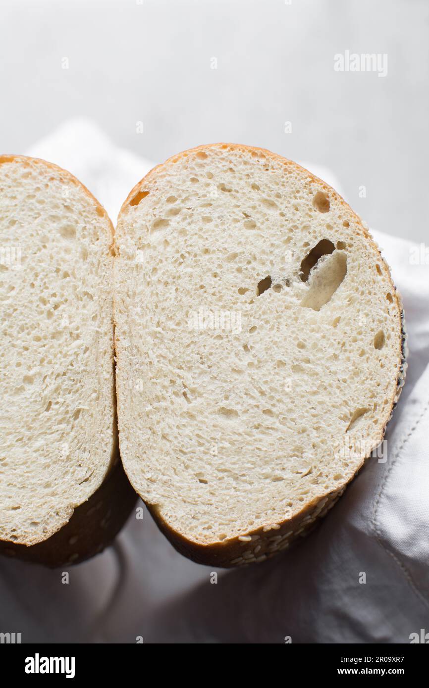 Cross-section of artisan bread cut into half, top view of sesame coated ...
