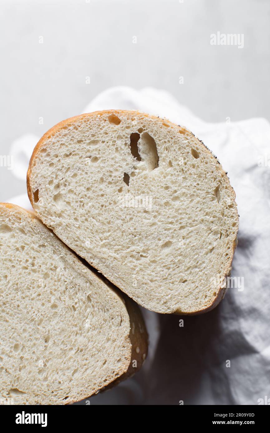 Cross-section of artisan bread cut into half, top view of sesame coated ...