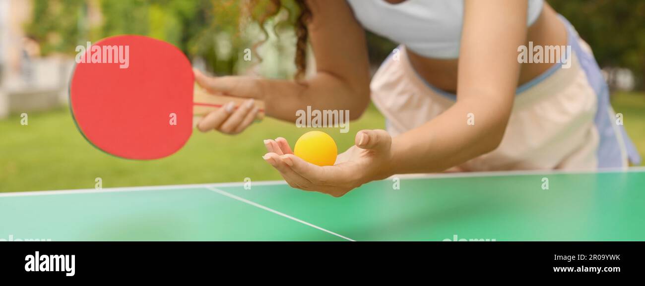 African-American woman playing ping pong outdoors, closeup. Banner ...