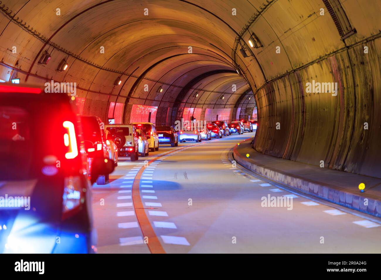 Line of cars stopped in heavy gridlock traffic in curved tunnel Stock ...