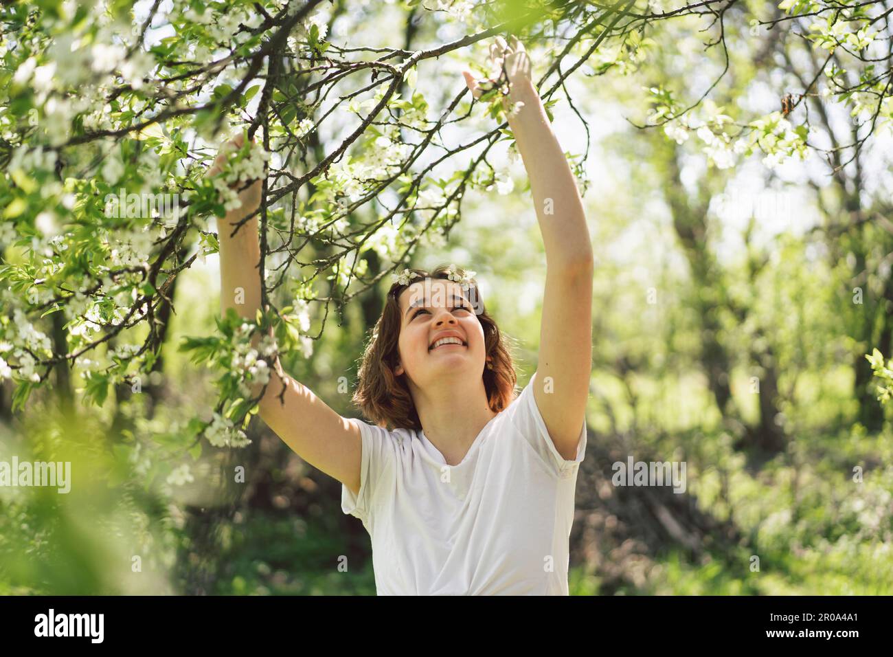 Beautiful teenage girl with spring flowers enjoying nature and laughing ...