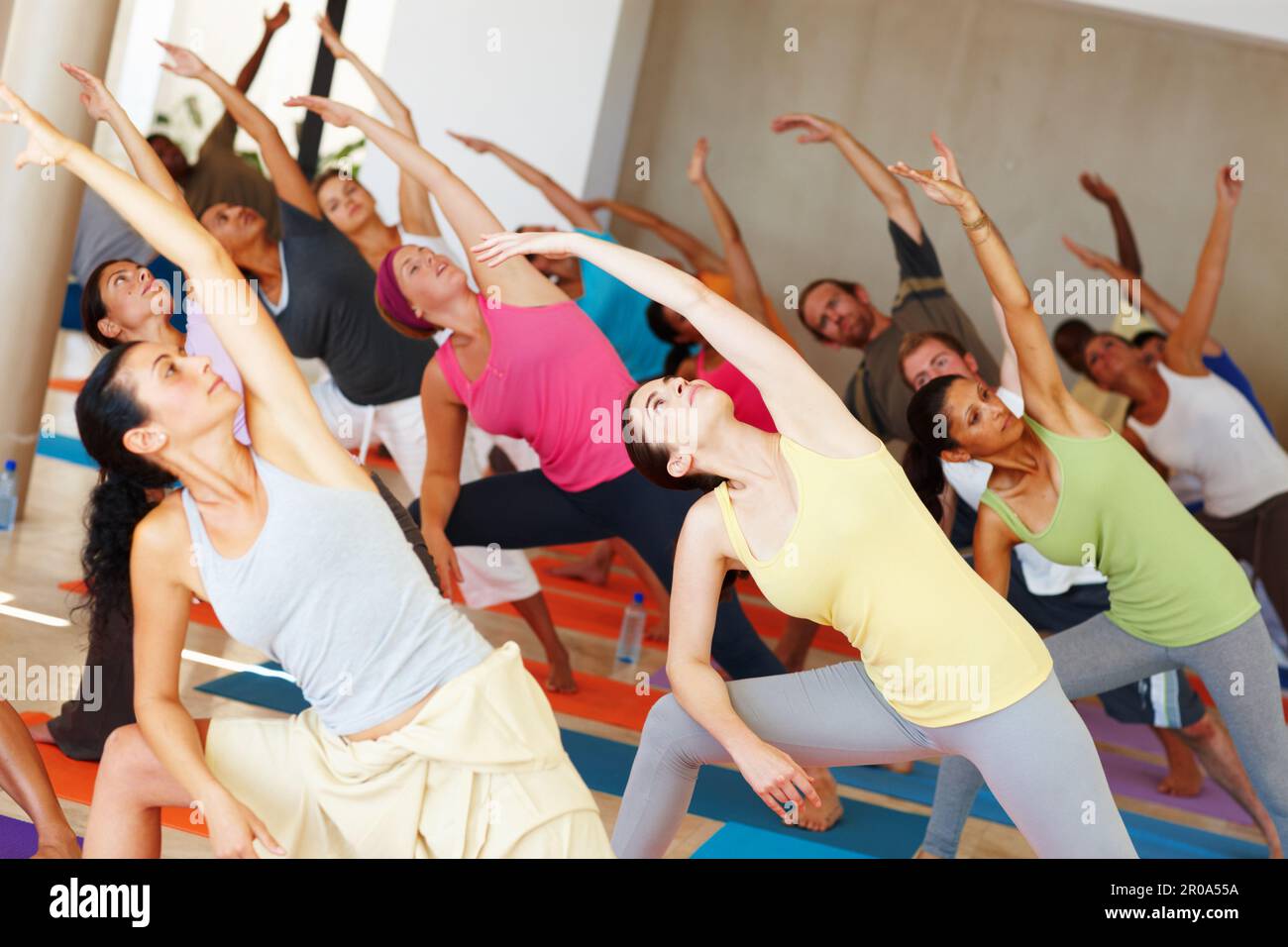 Reaching towards health with yoga. a diverse group of yoga students ...