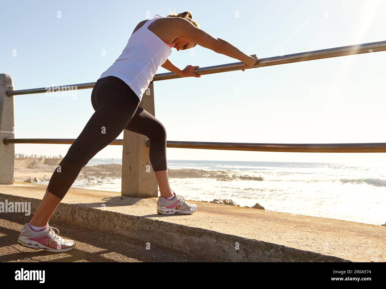 Working out starts from within. A young female runner stretching her ...