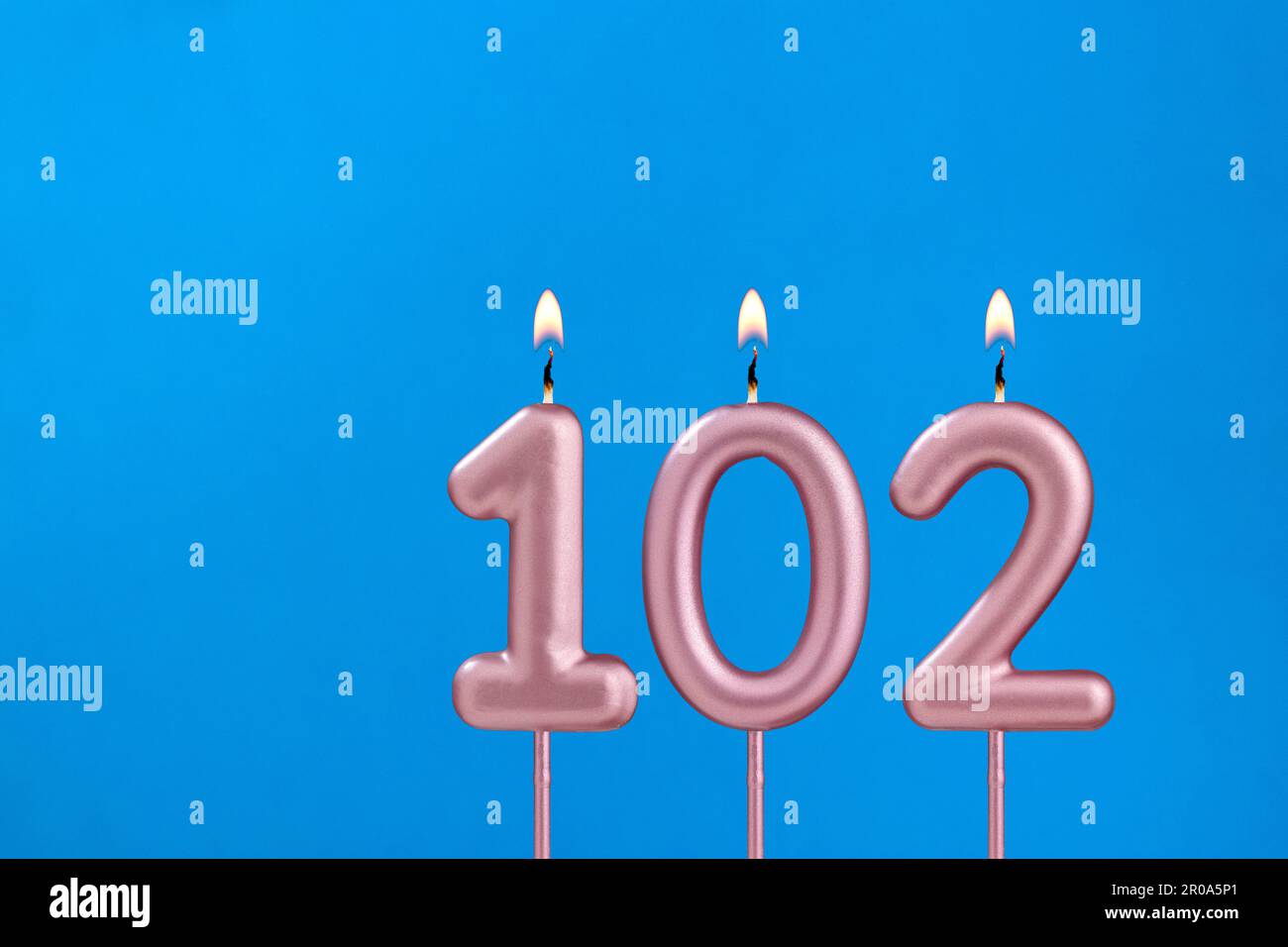 Candle number 102 - Birthday in blues foamy background Stock Photo - Alamy