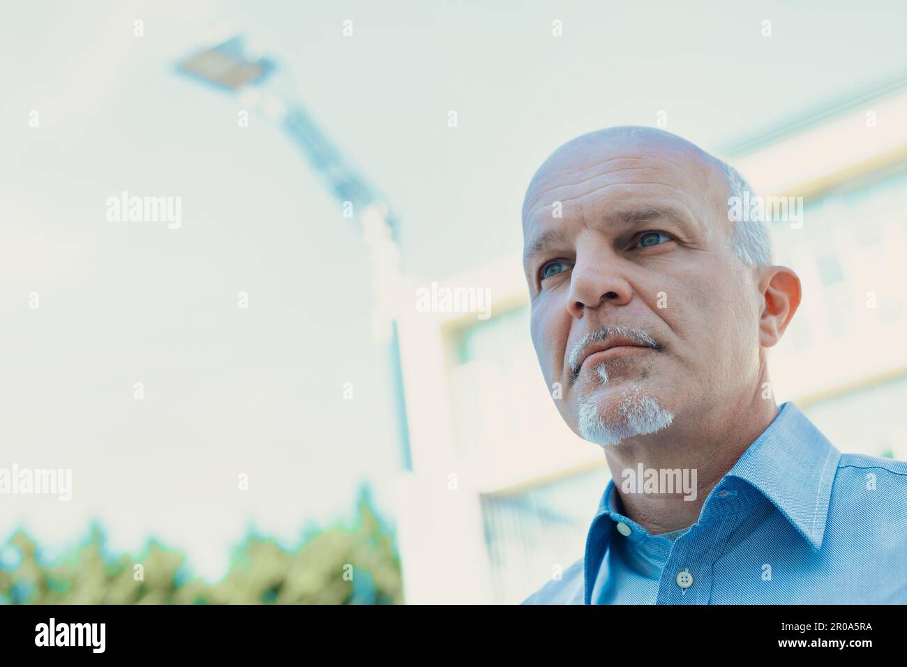 View from below of a mature man's face peering into the distance ...