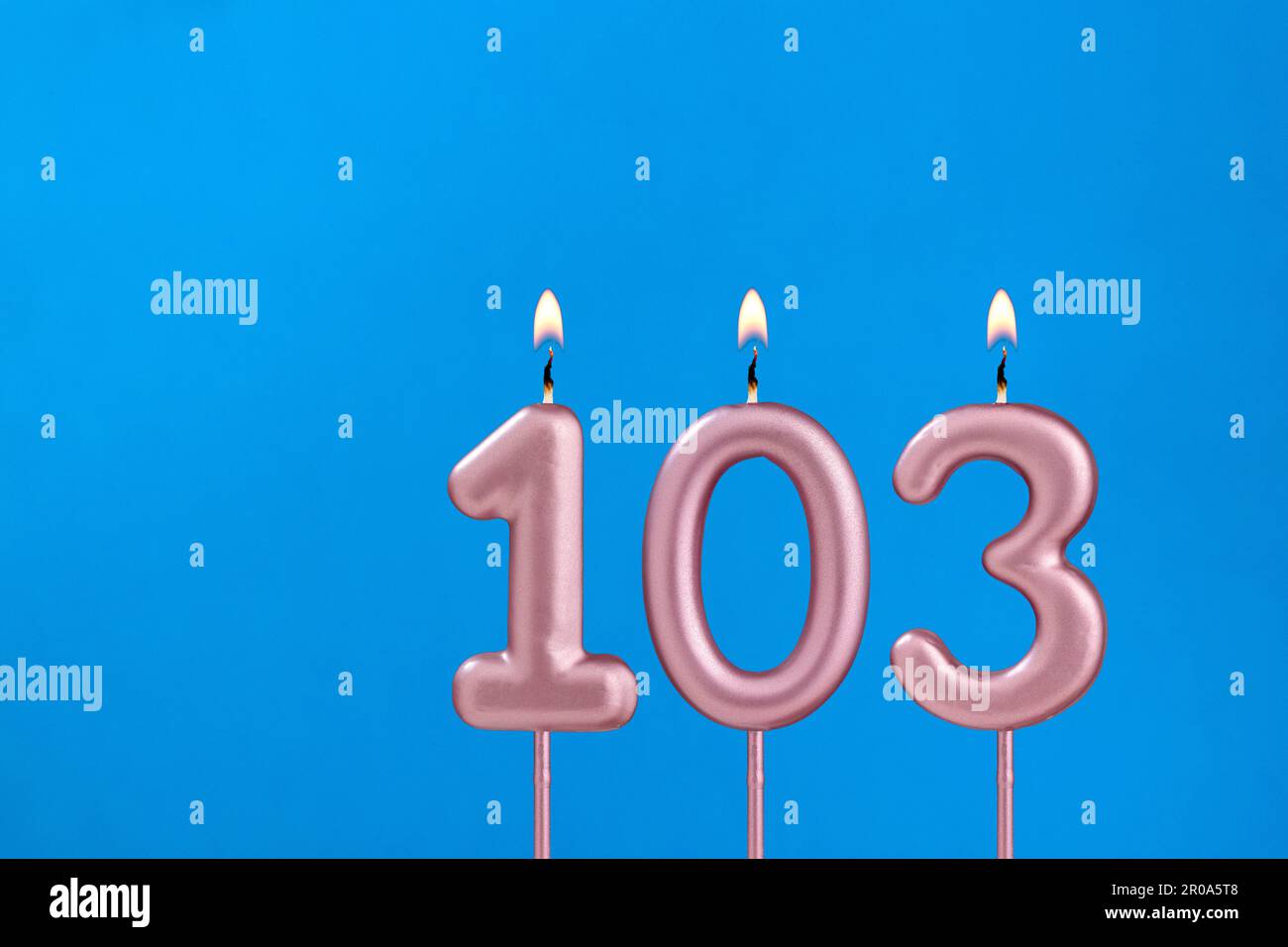 Number 103 - Burning anniversary candle on blue foamy background Stock ...