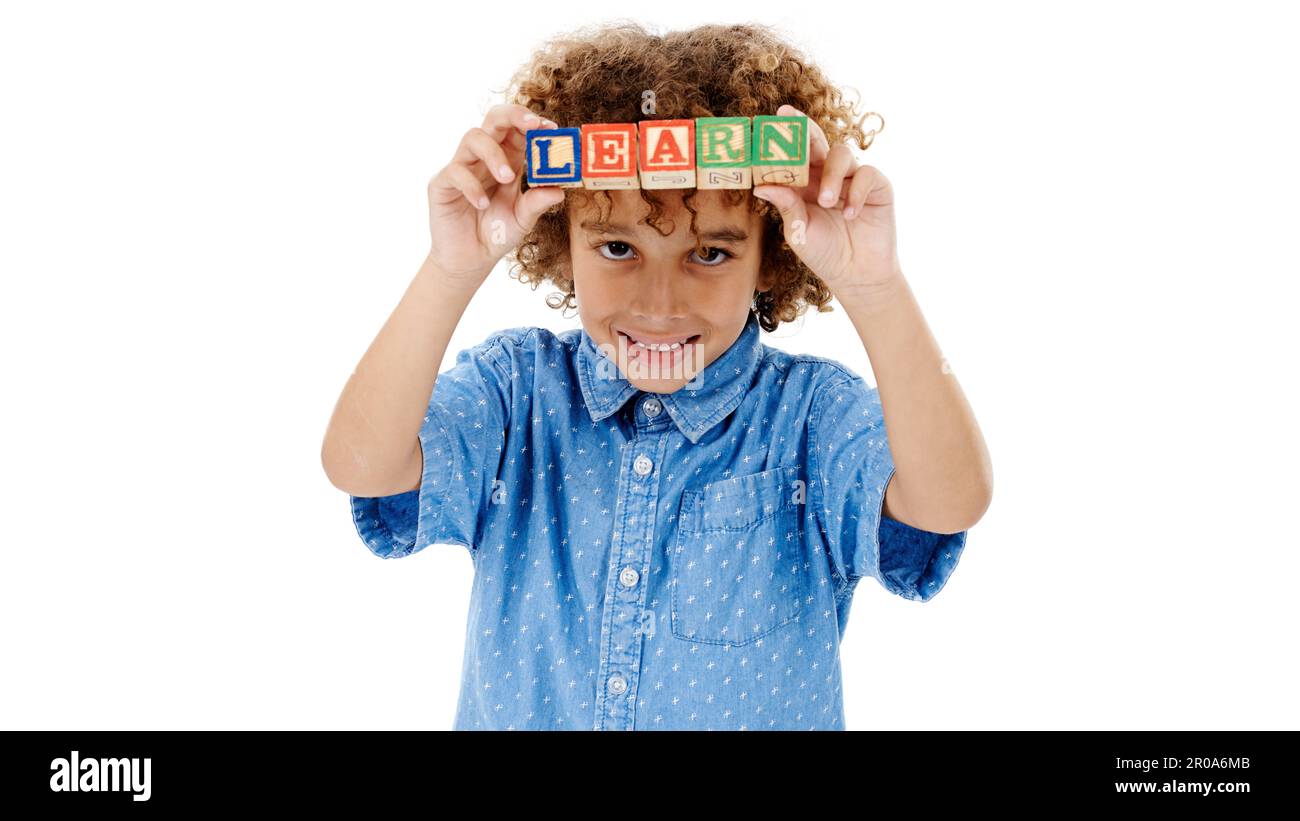 Learning is childs play. Studio shot of a cute little boy holding ...