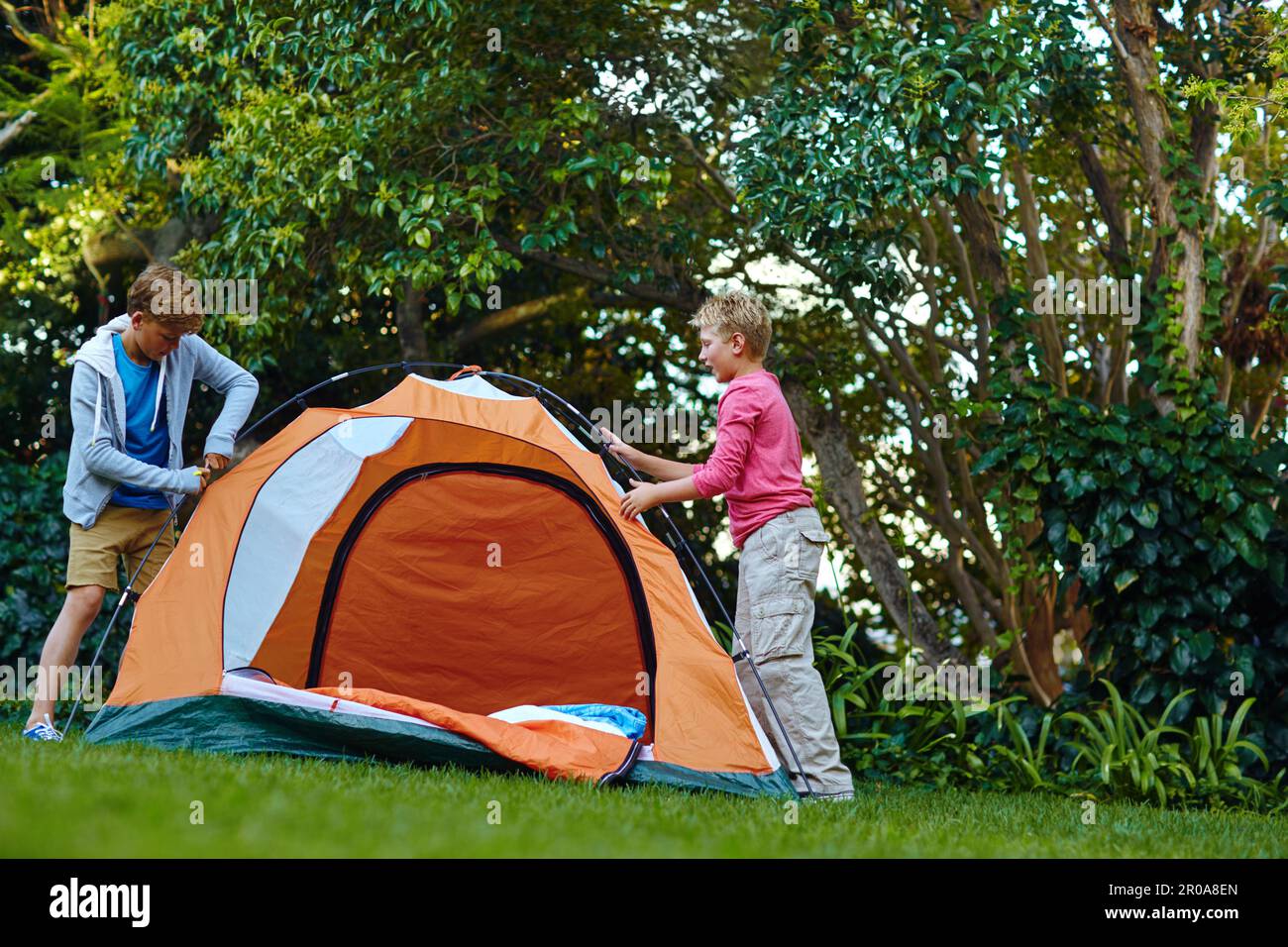 Camping- the fun begins here. two young boys putting up their tent ...