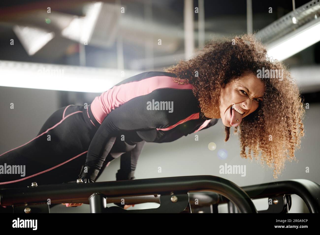 Strong is my motivation. a young woman doing planche pushups at the gym ...