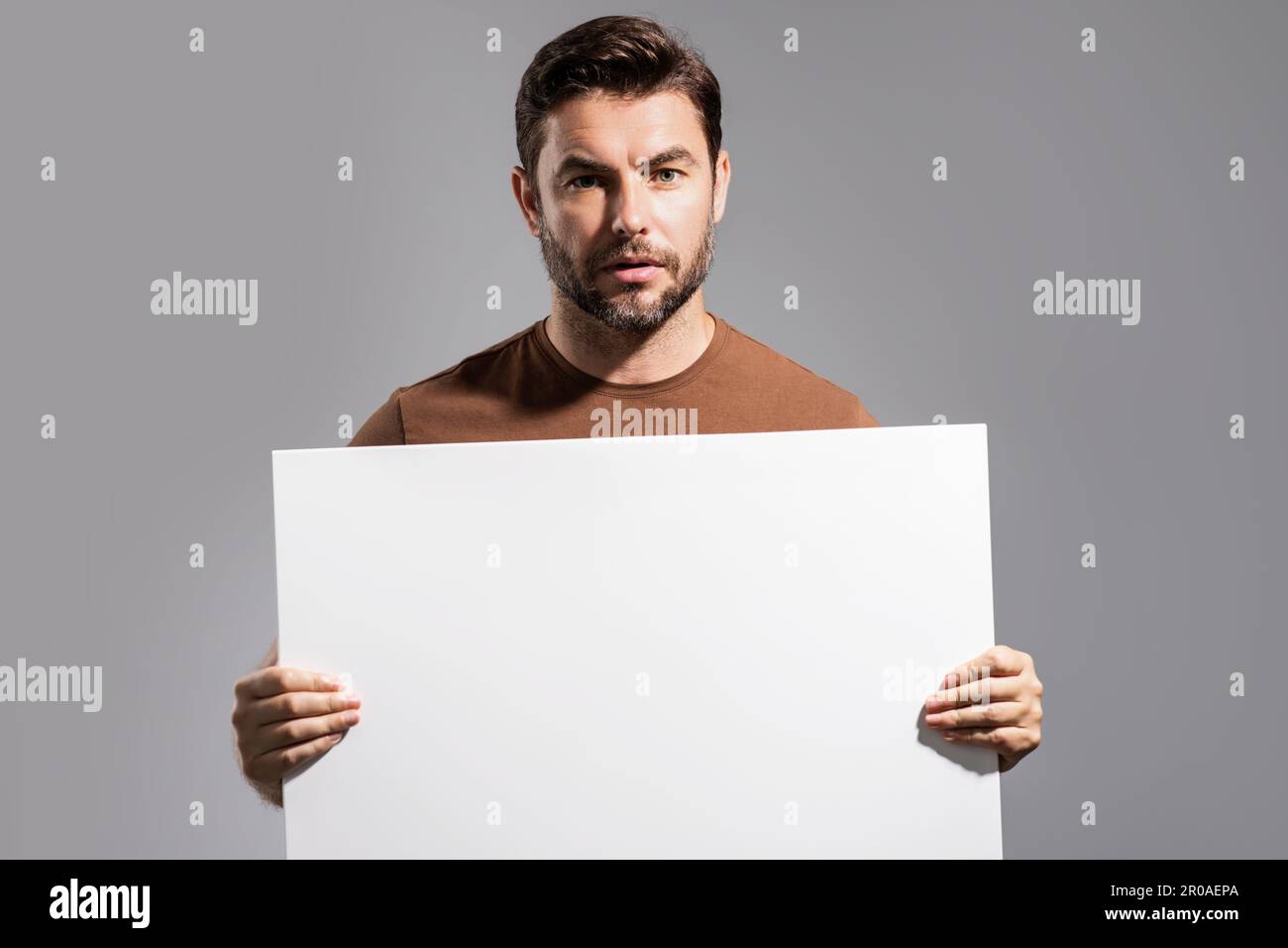 Man with empty blank banner ad on studio background. Portrait of ...