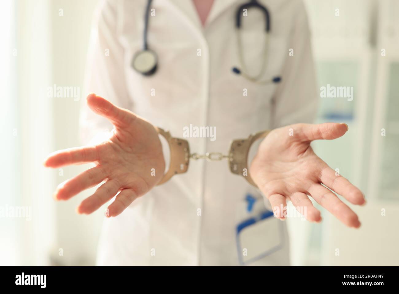Doctor with stethoscope in handcuffs. Nurse with metal handcuffs on ...