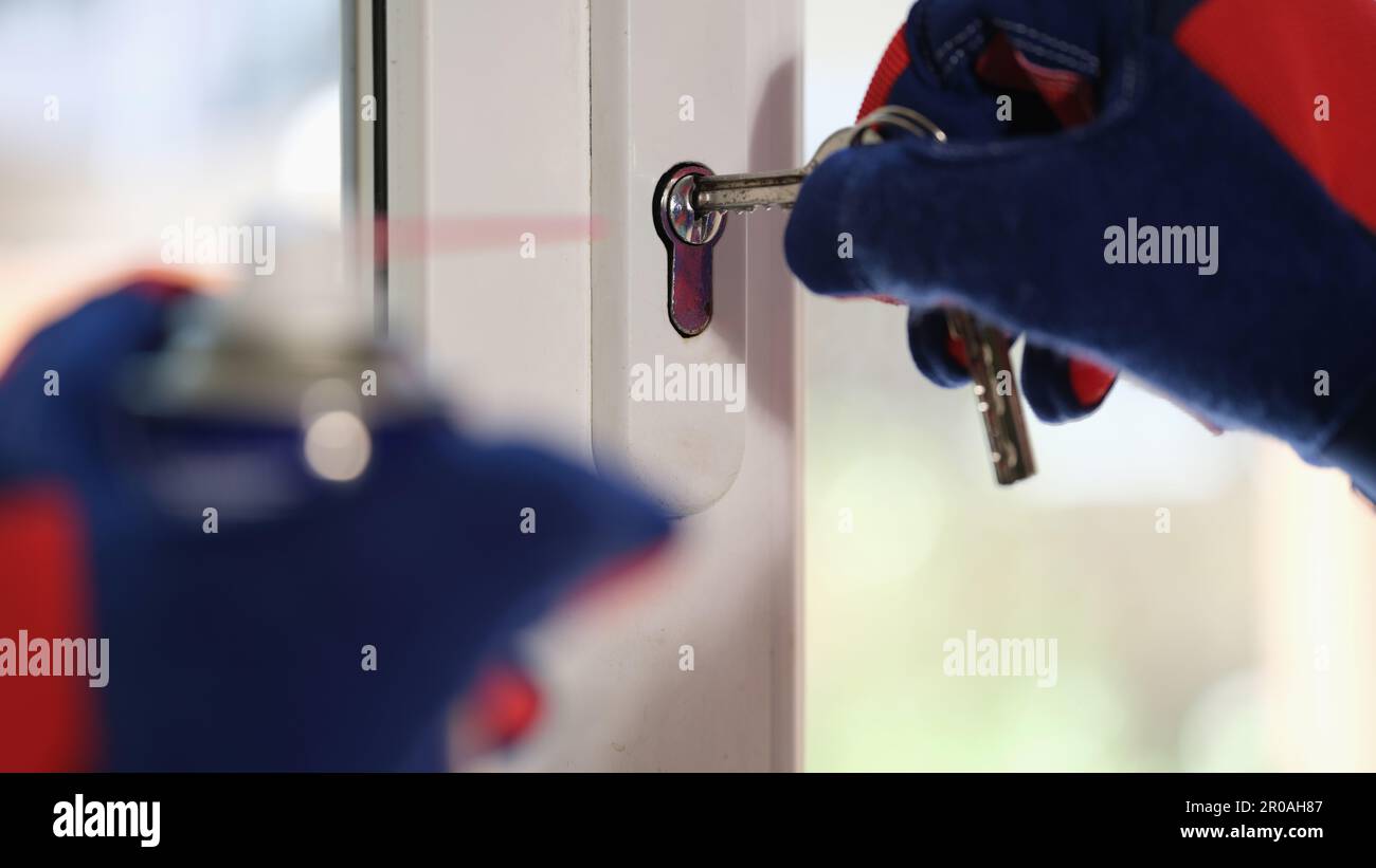 Master in gloves checking pvc windows locks with keys Stock Photo - Alamy
