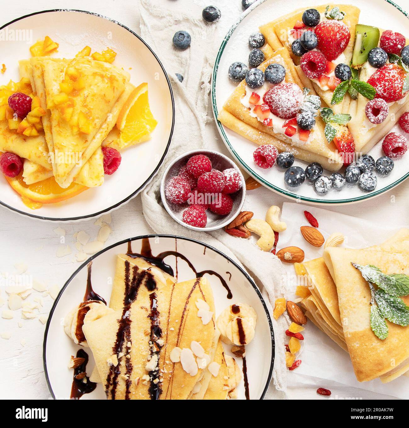 Variety of fresh crepes with chocolate, jam, fruits and berries on ...